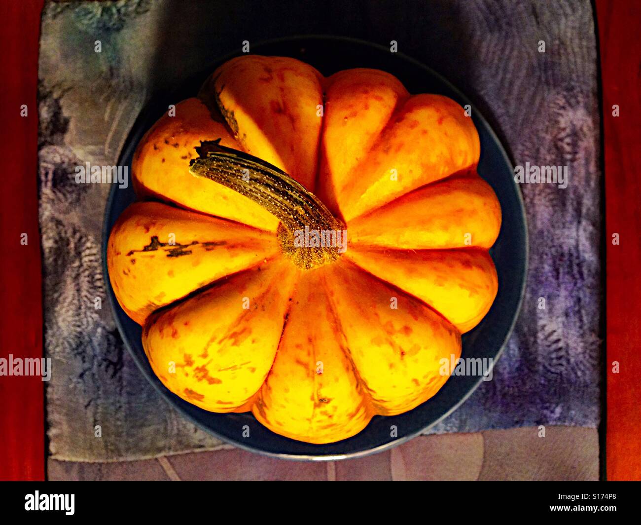 Decorative gourd on blue plate Stock Photo - Alamy