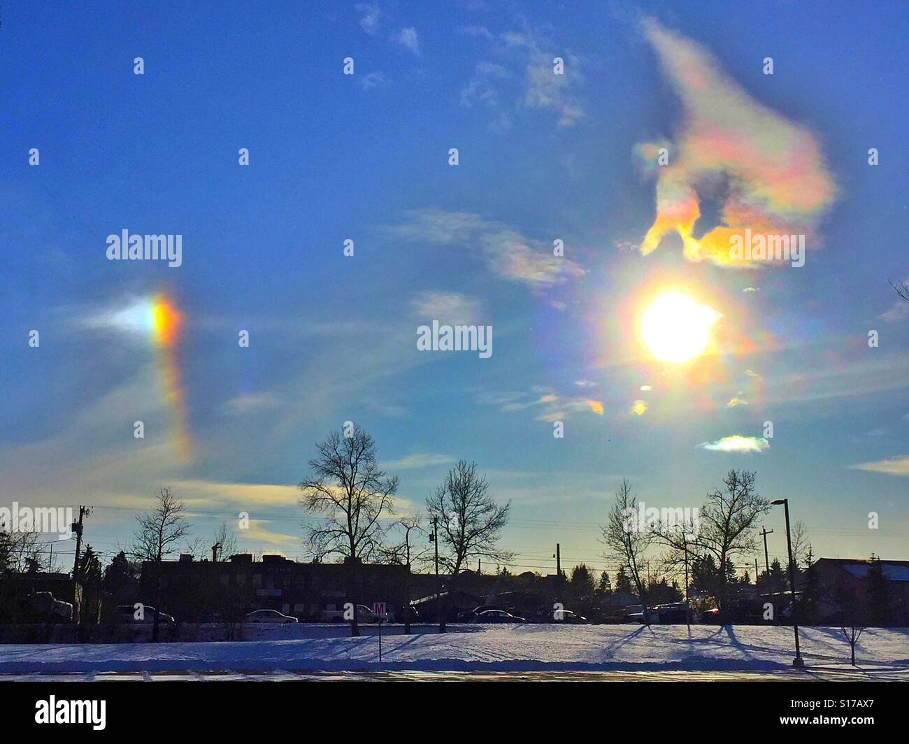 Bright sun and sun dog with colourful reflection in a nearby cloud ...