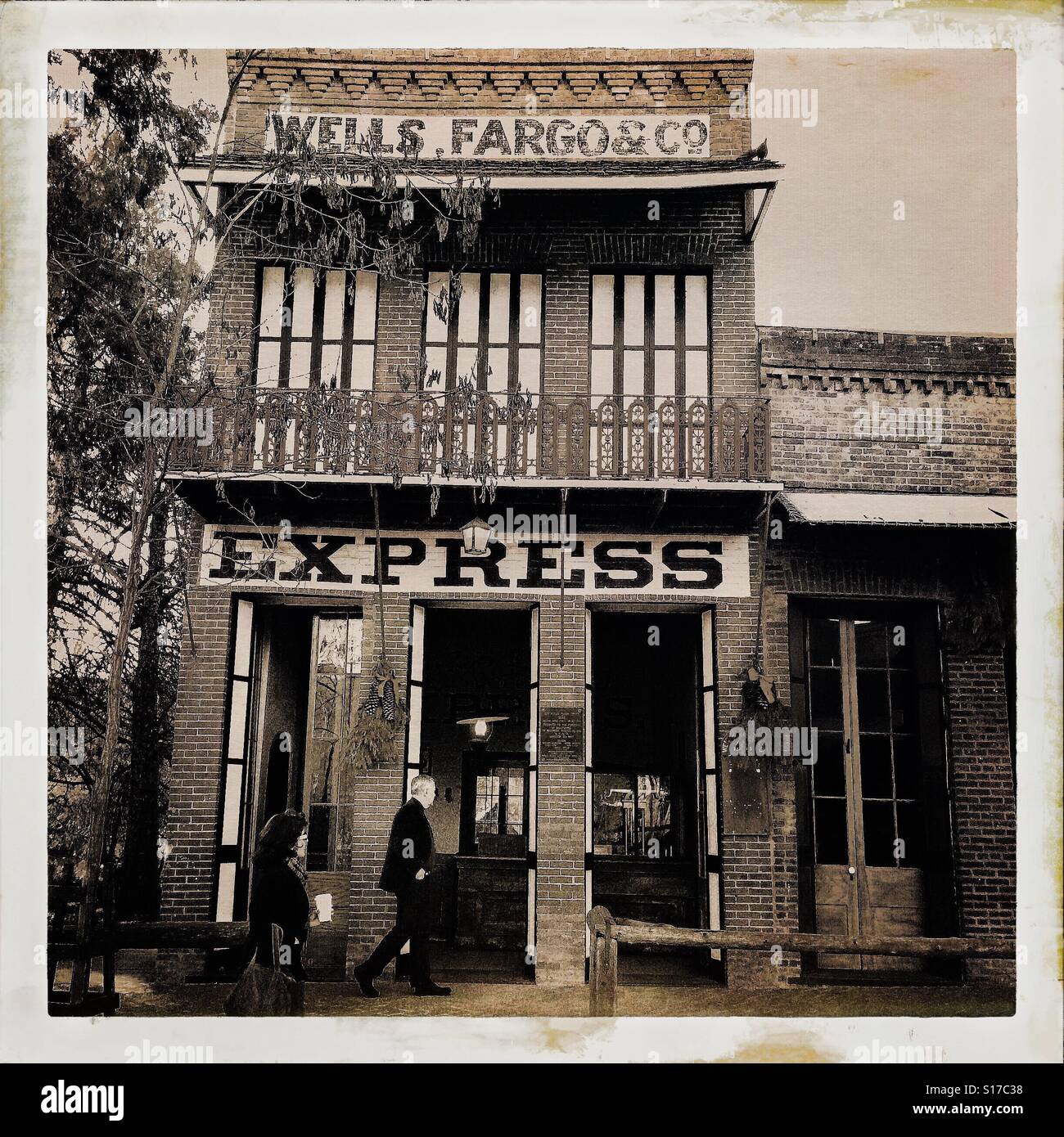 Tourists walk past the Wells Fargo and Company building on Main Street ...