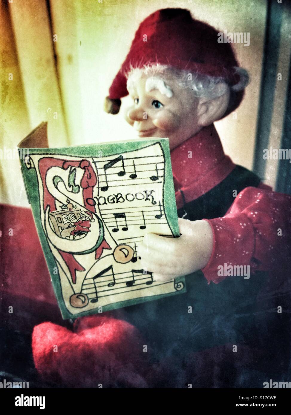 Christmas Elf Reading in his songbook photo with retro filter Stock ...