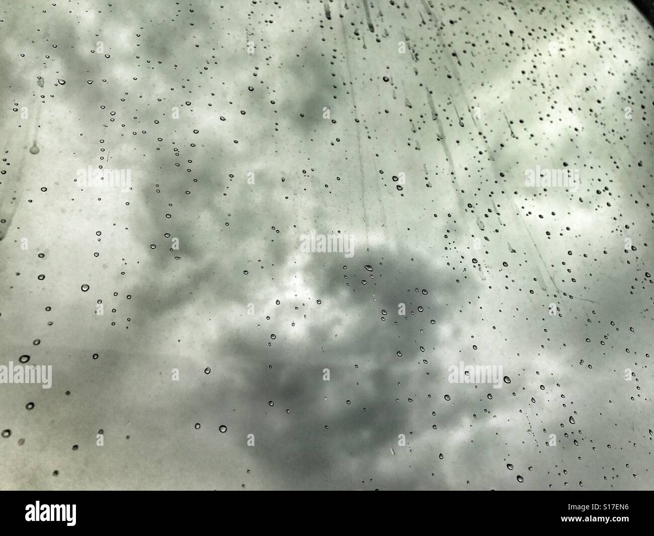 Raining outside with droplets on the window glass Stock Photo - Alamy