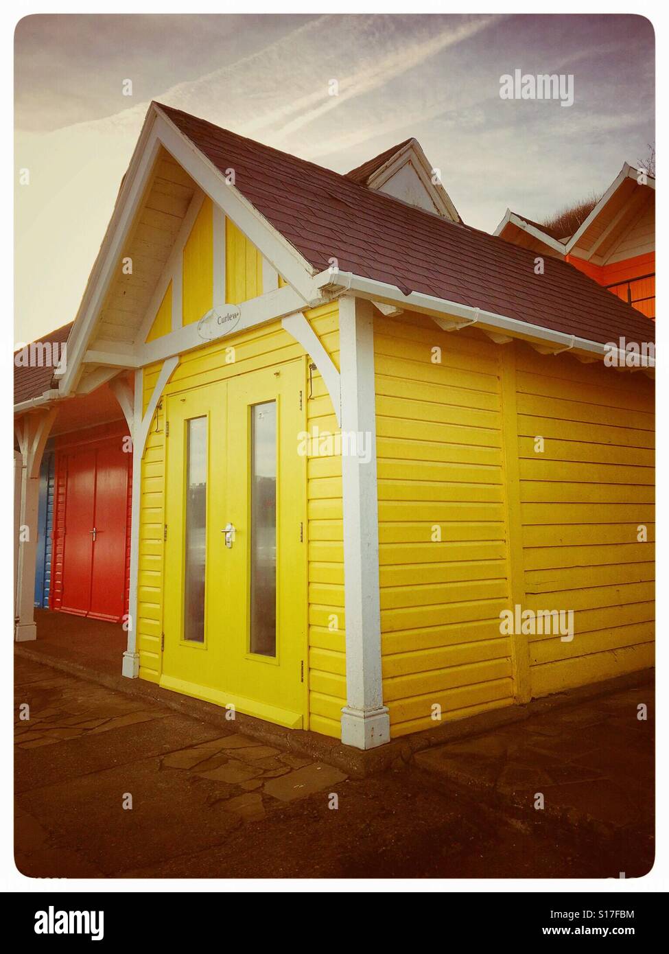 Yellow painted beach hut closed for the winter season Stock Photo - Alamy
