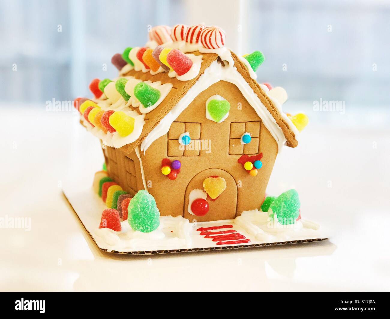 Christmas decorating a gingerbread house Stock Photo - Alamy