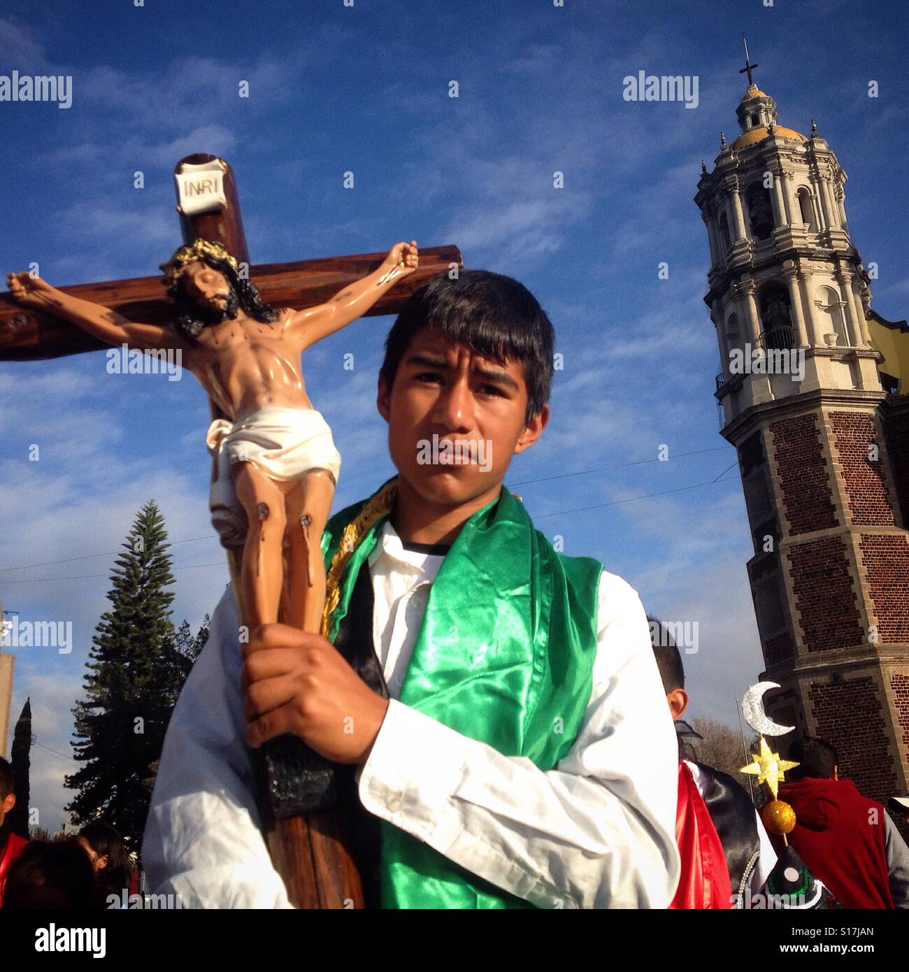 A young pilgrim holds an image of Jesus Christ crucified during the ...