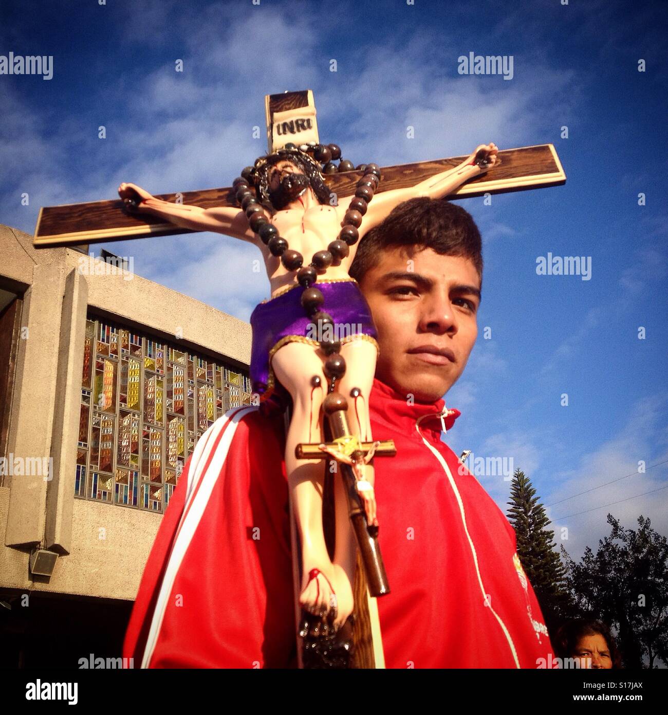 A young pilgrim holds a sculpture of Jesus Christ crucified during the ...