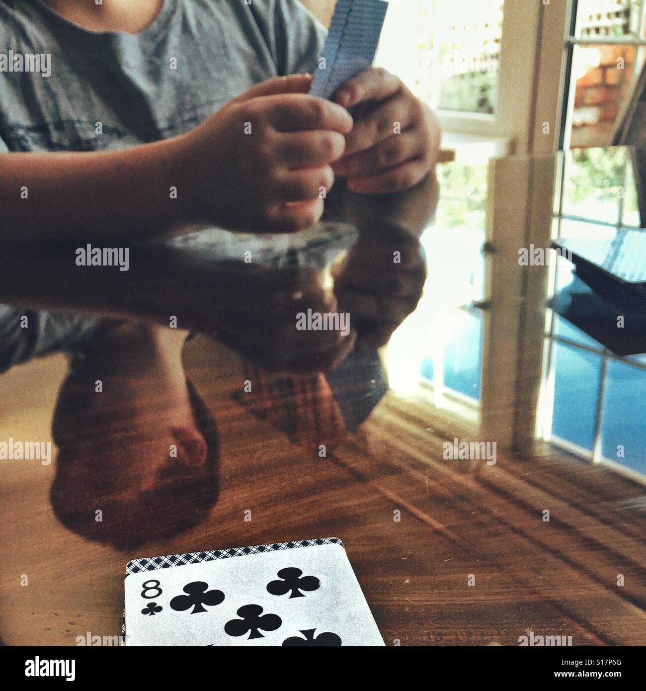 Reflection of child playing cards Stock Photo - Alamy