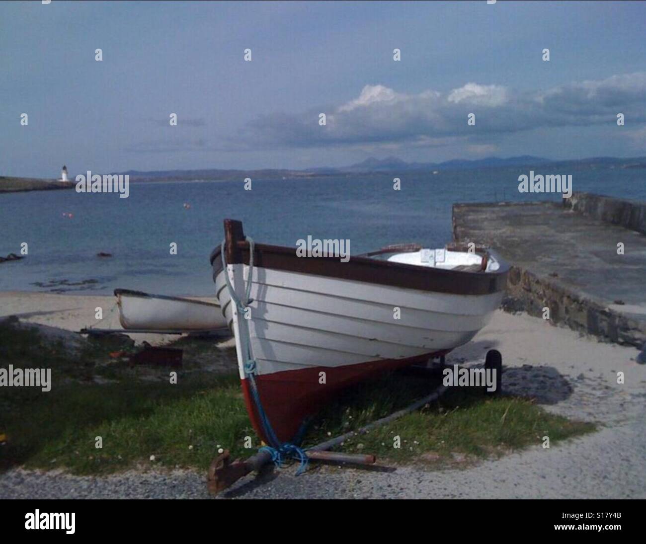 Little fishing boat on the Scottish island is Islay near shore street ...
