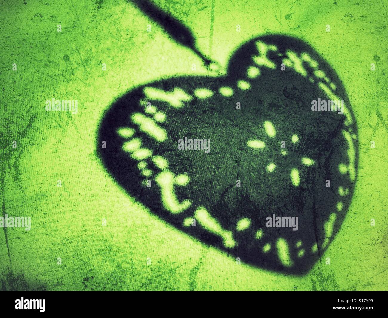Heart shaped shadow on green fabric Stock Photo - Alamy