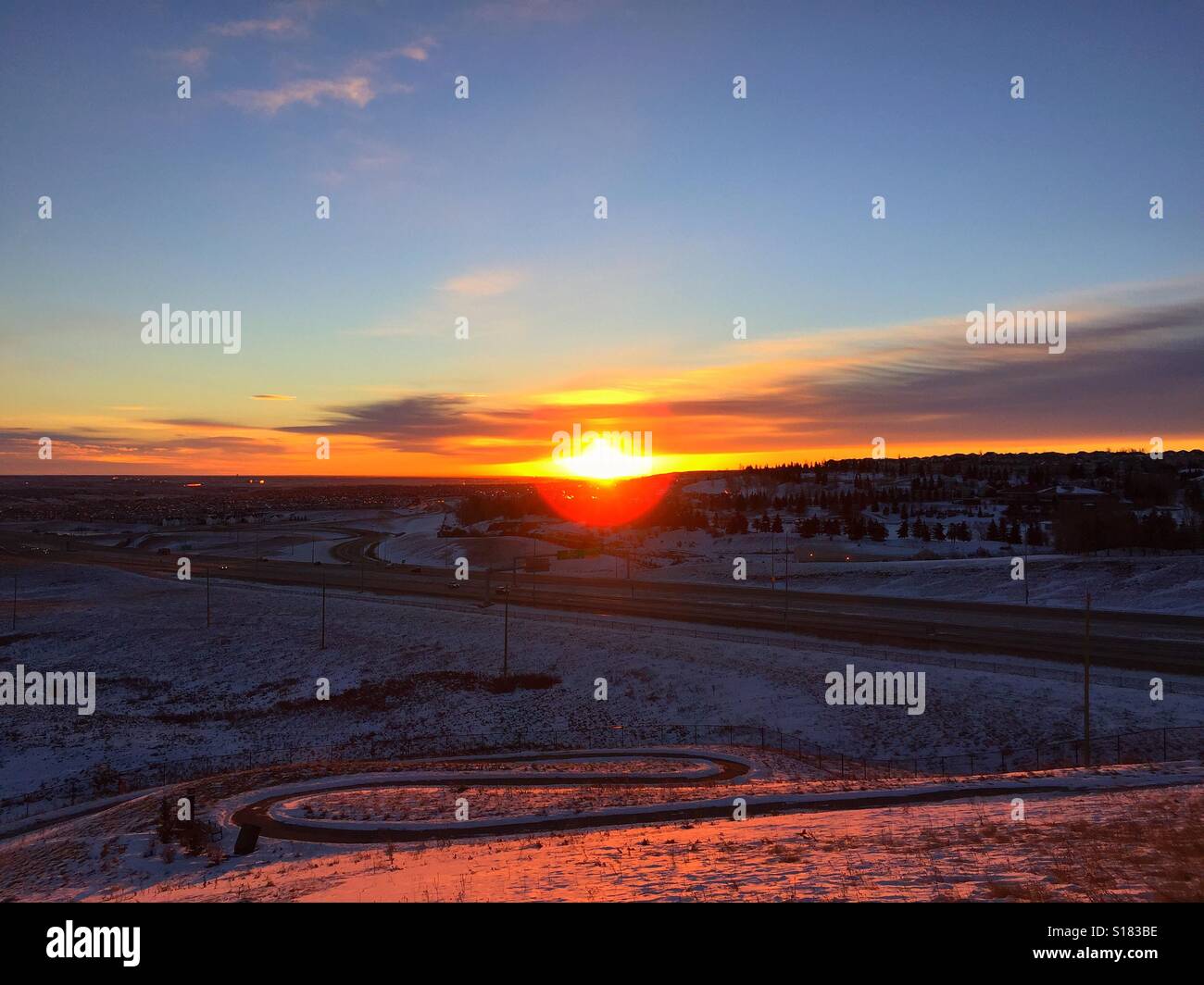 Sunrise with lens flare. Busy street and curved pathway. Calgary ...