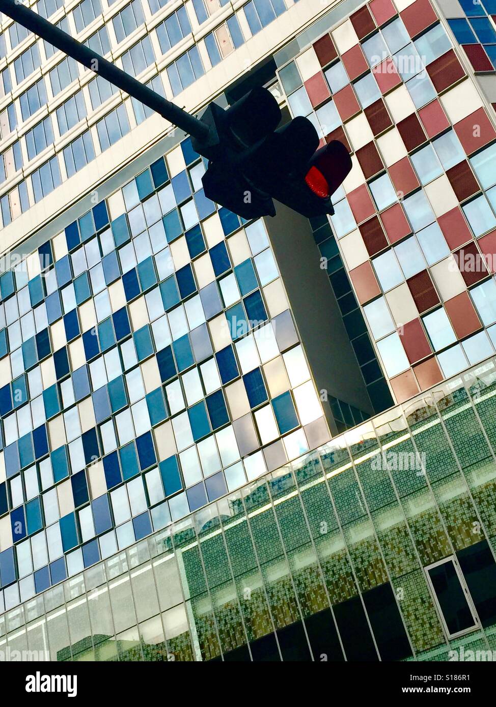 Traffic light against a colourful glass wall of a building hi-res stock ...