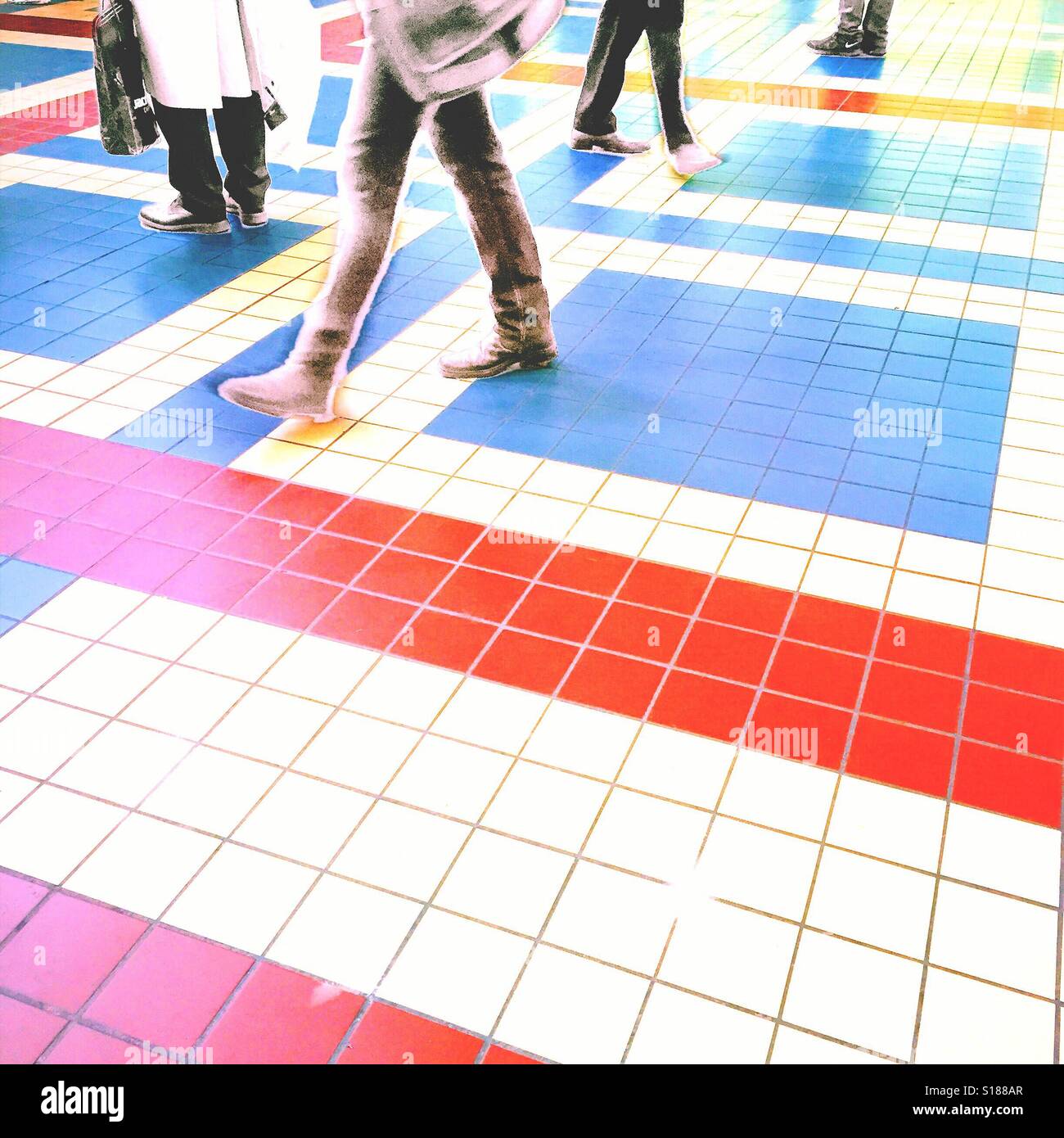 Commuters walking over a colourful station tiled floor Stock Photo - Alamy