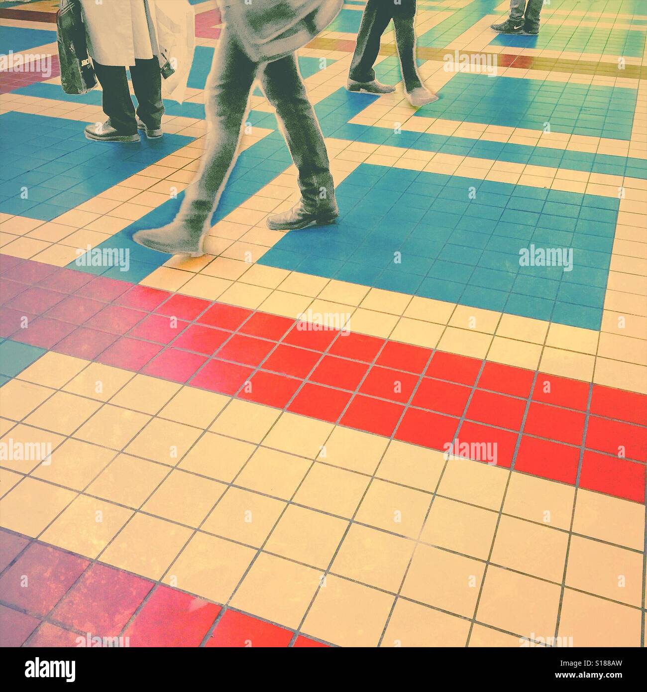 Commuters walking over a colourful station tiled floor Stock Photo - Alamy
