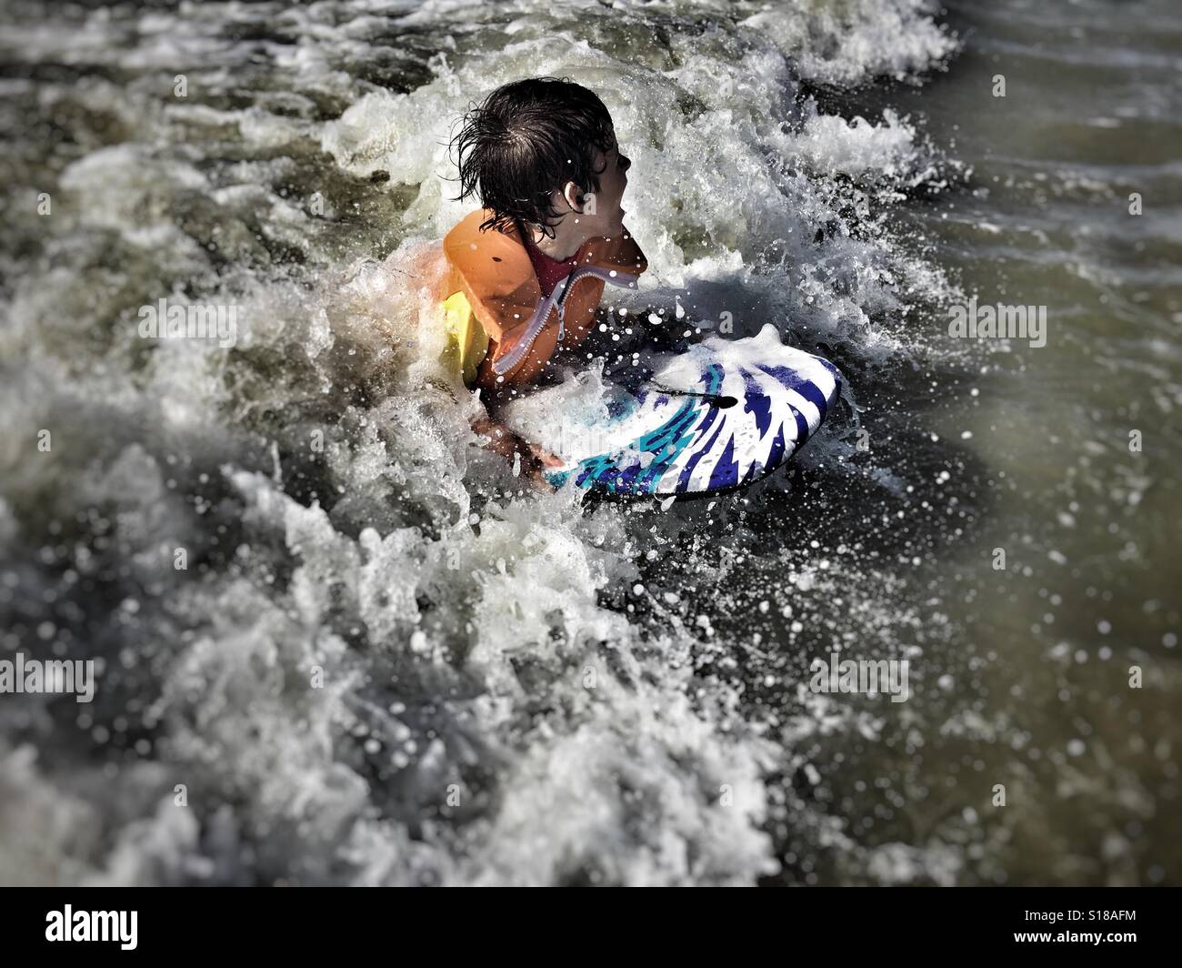 Young boy boogieboarding Stock Photo - Alamy