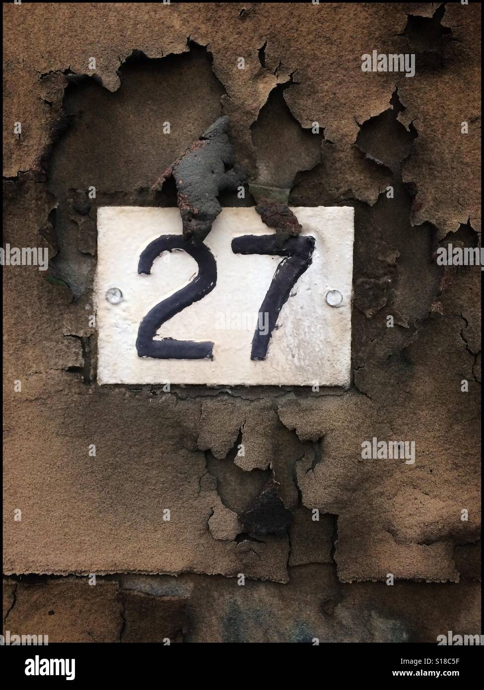 A house sign against a peeling sandstone wall in Glasgow, Scotland ...