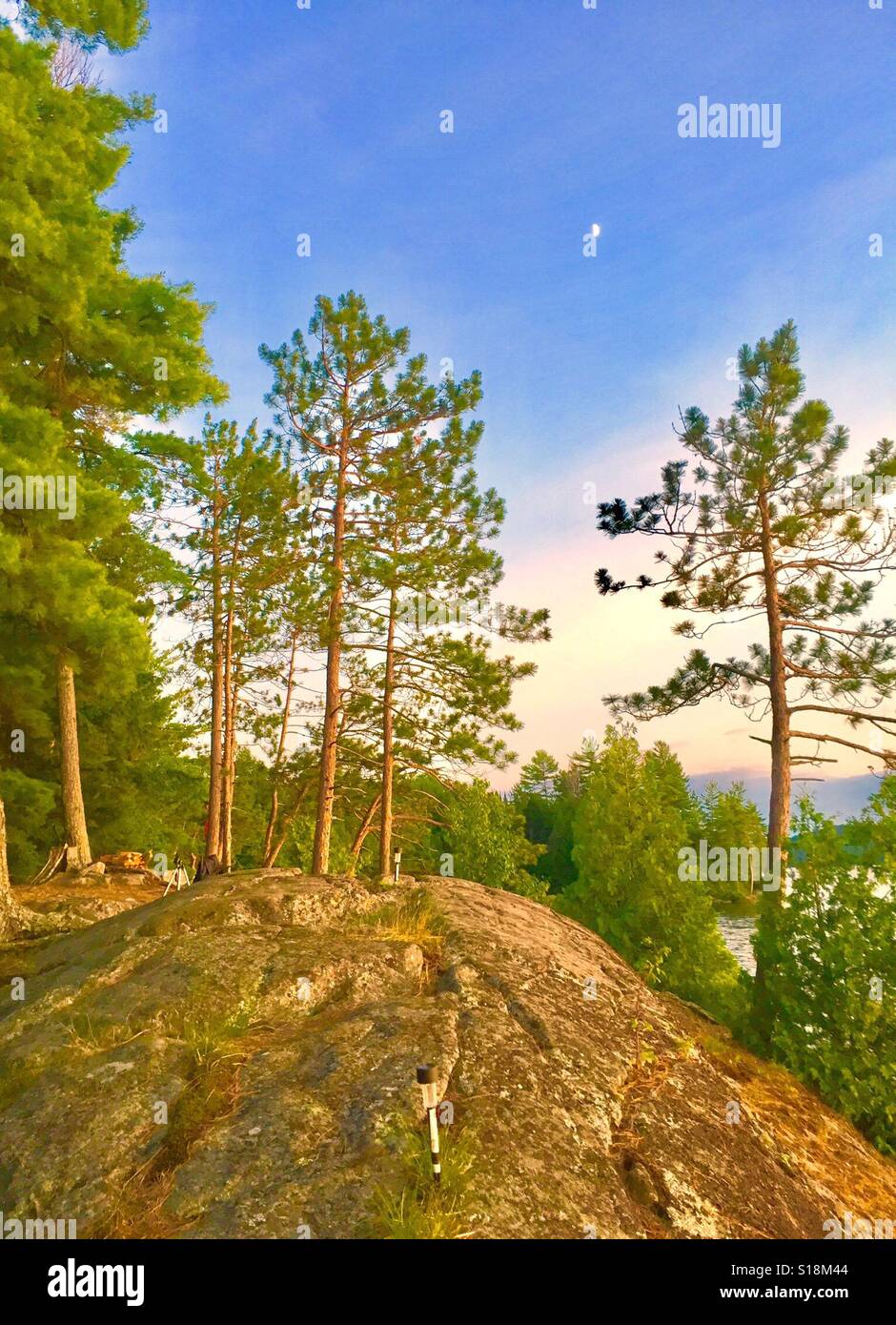 Rock Outcrop With Solar Lights And Moon Over Forest Lake Portrait Stock ...
