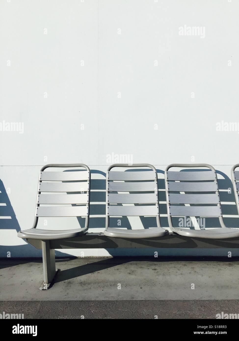 Aluminum seating with graphic shadow Stock Photo - Alamy