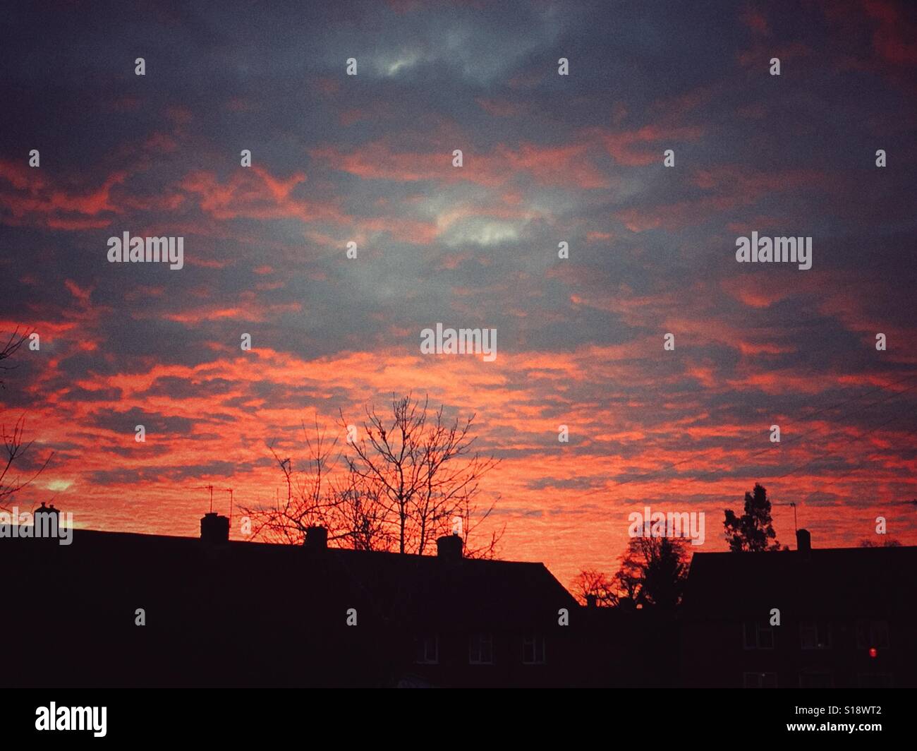 Sunset over houses Stock Photo - Alamy