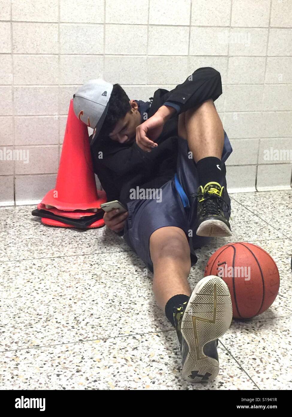 Boy relaxing following basketball practice Stock Photo - Alamy