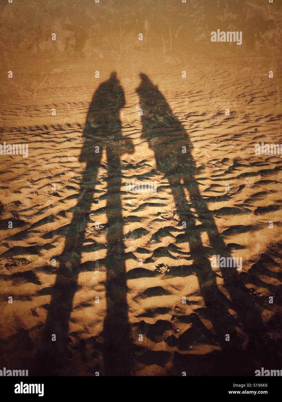 Shadow of two people on the beach Stock Photo - Alamy