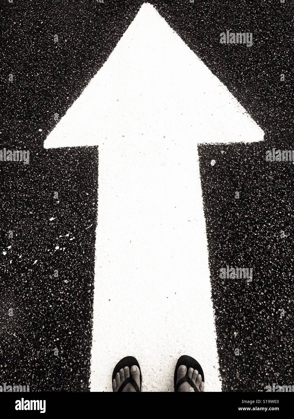 Standing on the arrow sign Stock Photo - Alamy