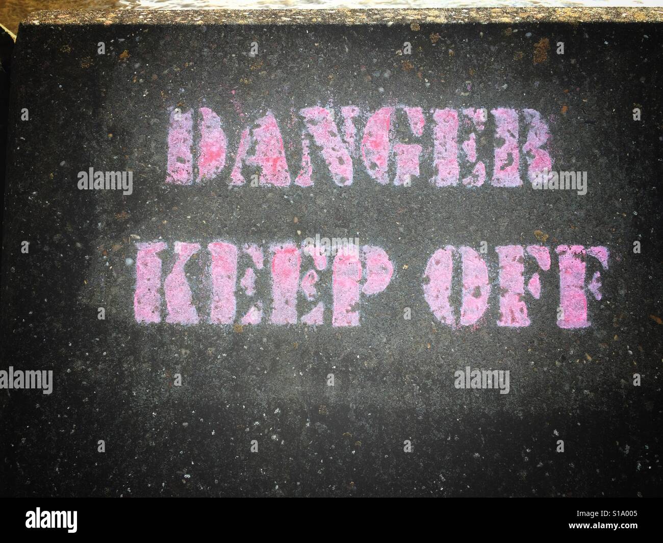 Danger keep off sign painted in link on a sea wall Stock Photo - Alamy