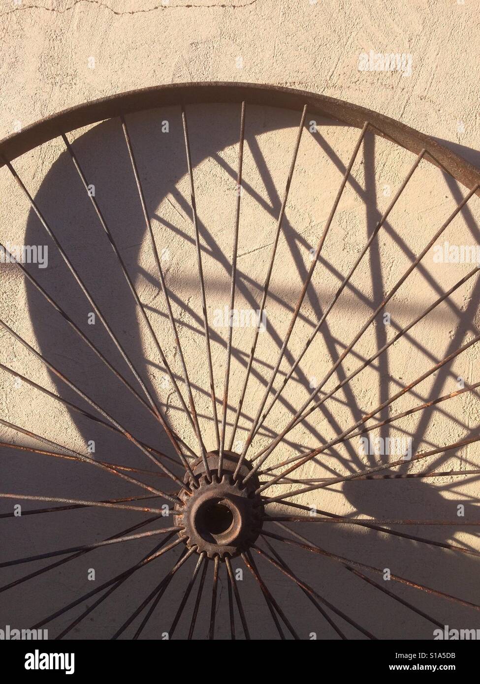 Old metal wheel with spokes, shadows Stock Photo - Alamy