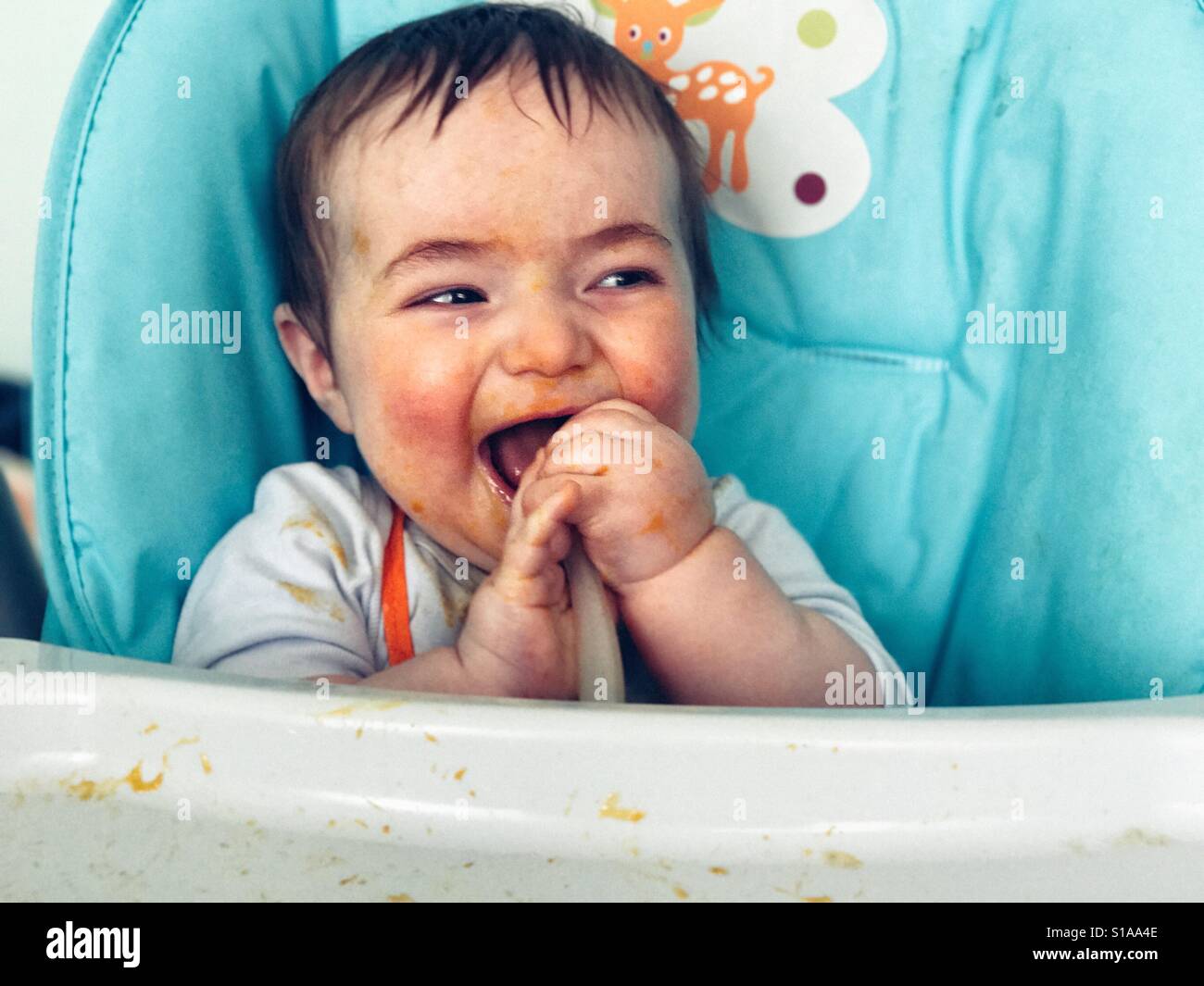 Baby eating messily Stock Photo - Alamy