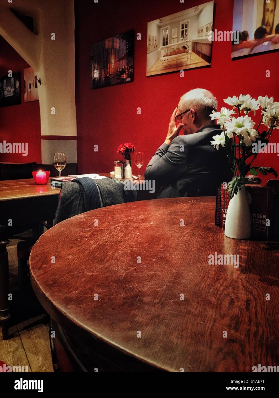 Man sitting inside a restaurant, looking sad Stock Photo - Alamy