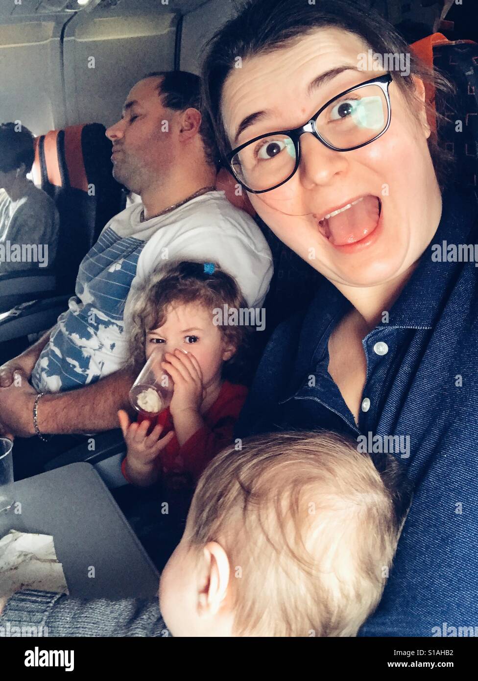 Family traveling on a plane Stock Photo - Alamy