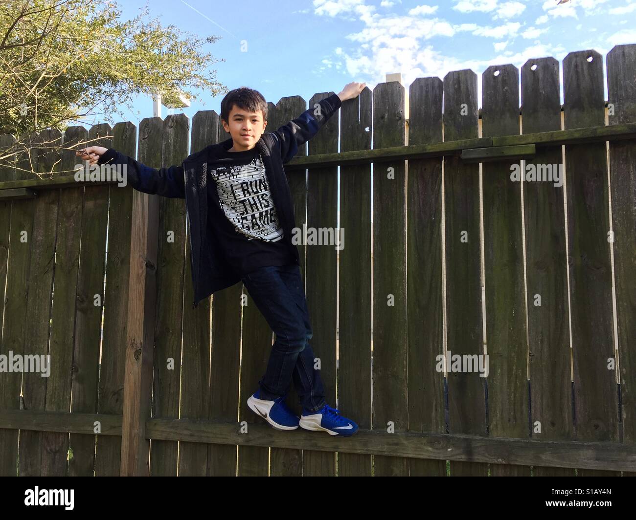 Kid on a fence Stock Photo - Alamy