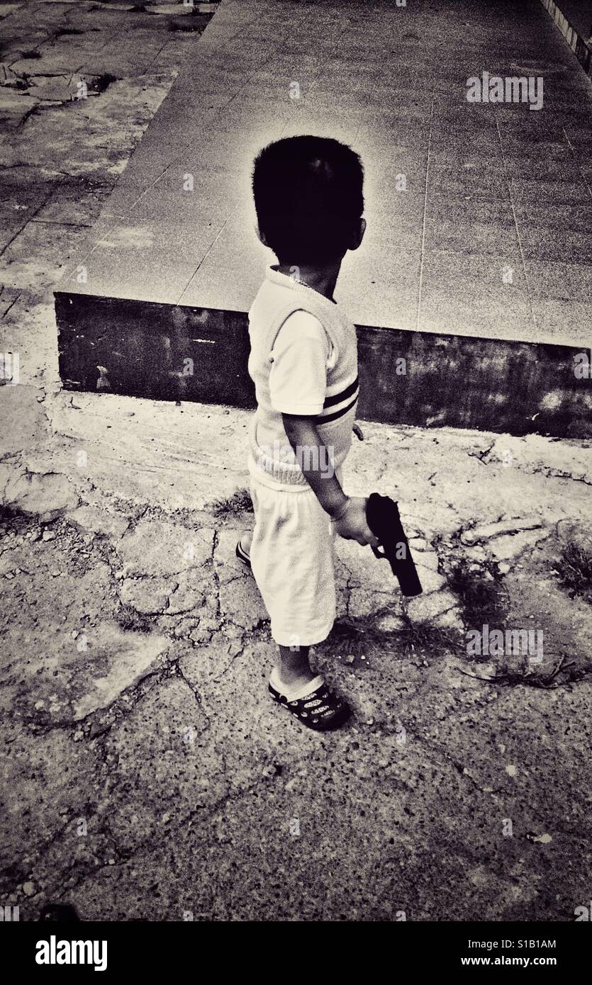 Young boy holding gun Stock Photo - Alamy