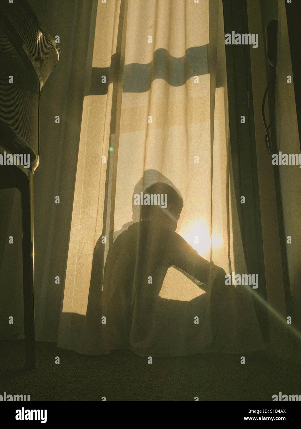 Young boy behind the window Stock Photo - Alamy