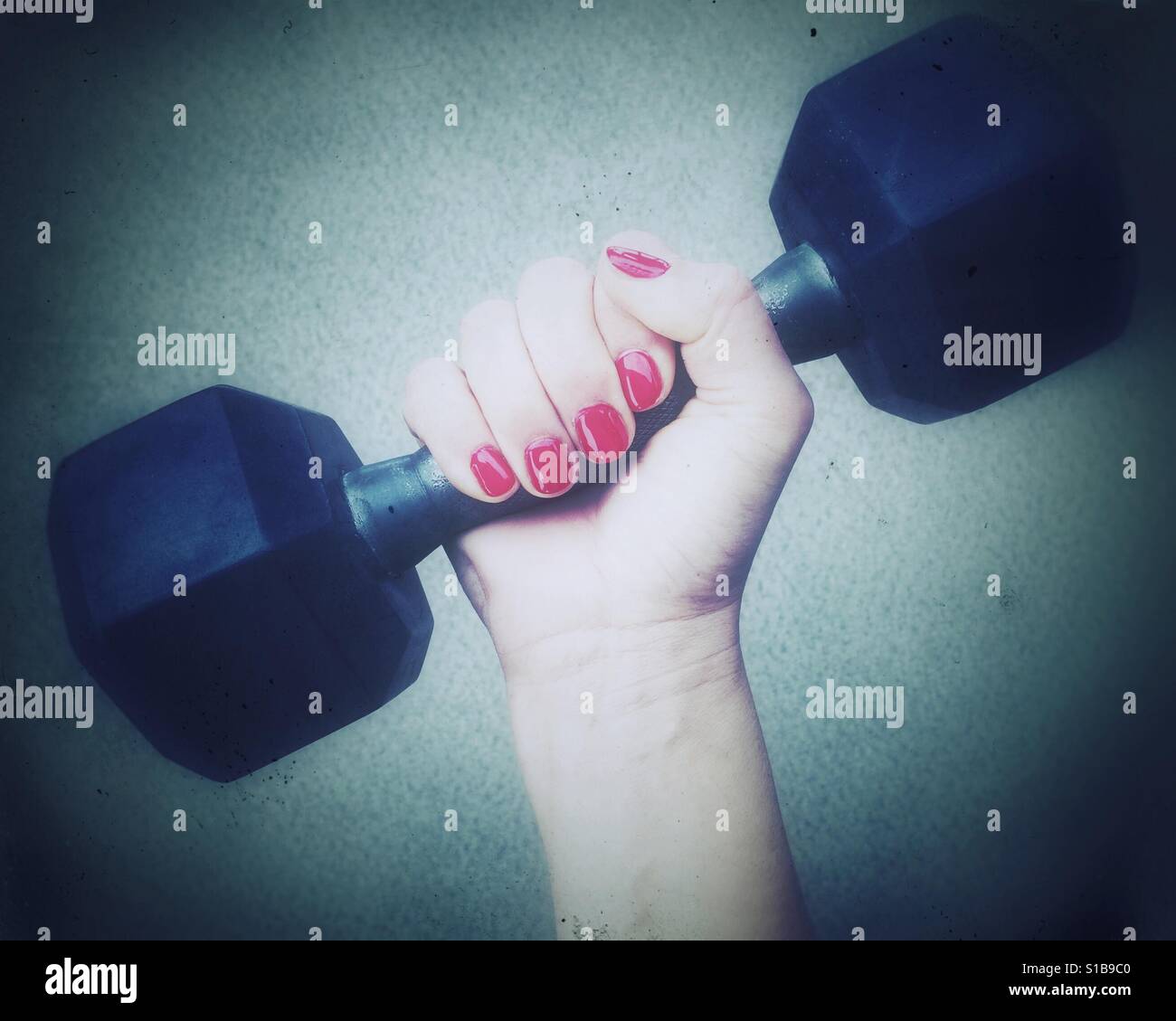 Close up of a woman's manicured hand gripping a dumbbell weight. Soft ... Close up of a woman's manicured hand gripping a dumbbell weight. Soft ...