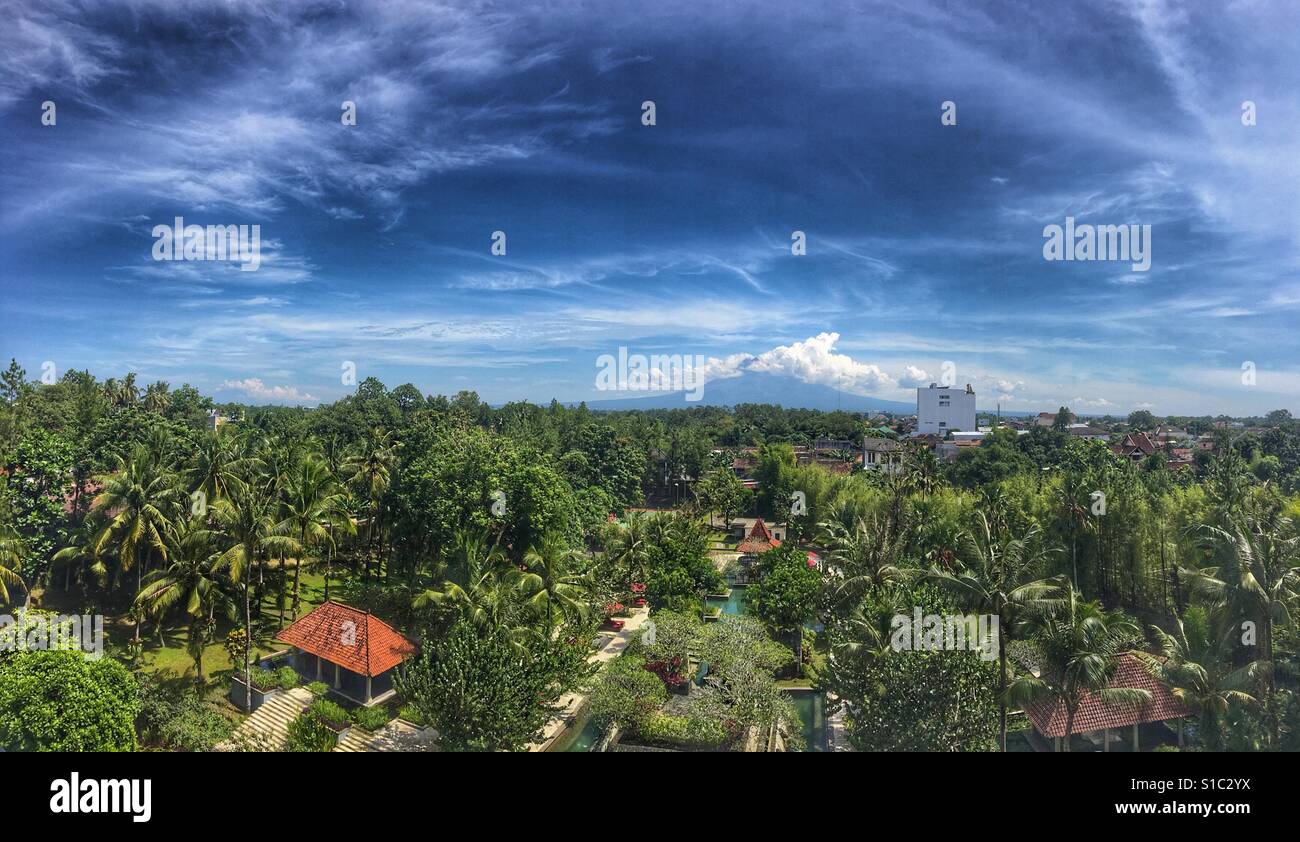 View of cloud-covered Mount Merapi from a rooftop in central Yogyakarta ...