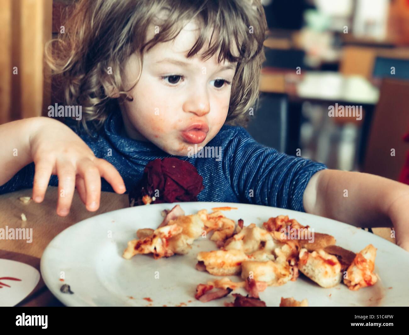 Two year old girl eating messily Stock Photo - Alamy