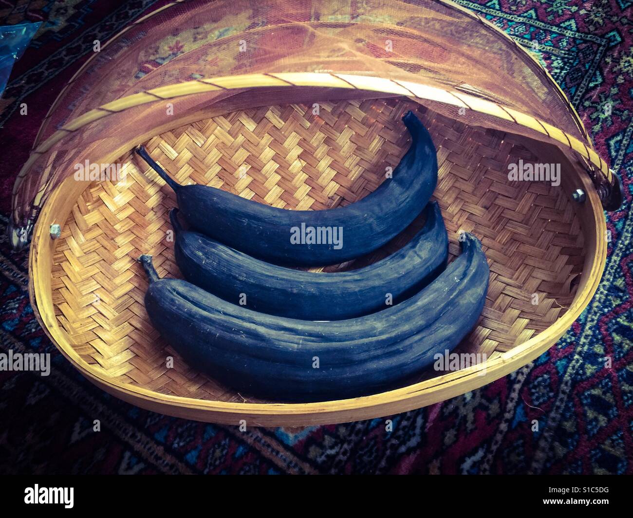 Three black plantains in an oval basket Stock Photo - Alamy