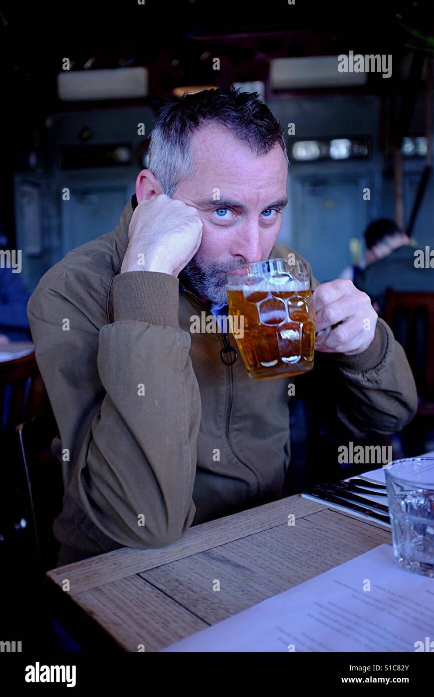 Man drinking a pint of beer in a pub Stock Photo - Alamy