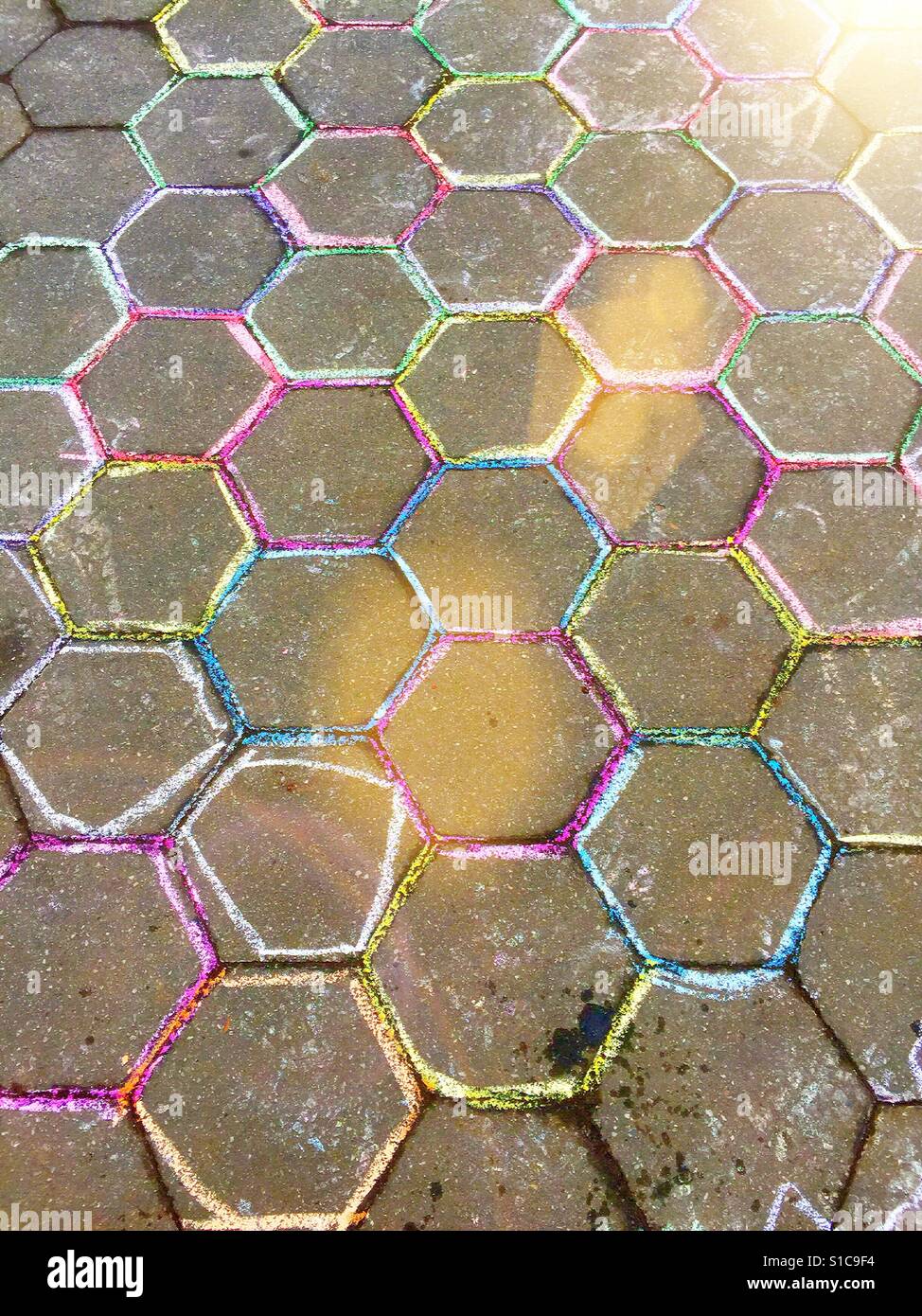 Sidewalk with hexagon paving stones outlined in multi colored chalk ...