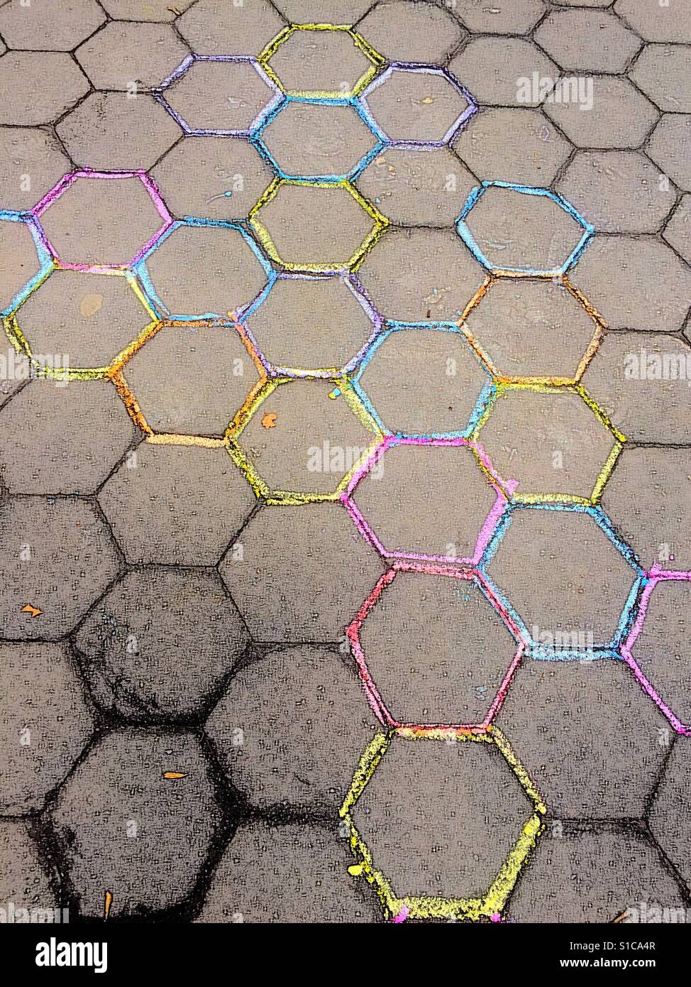 Sidewalk with hexagon paving stones outlined in multi colored chalk ...