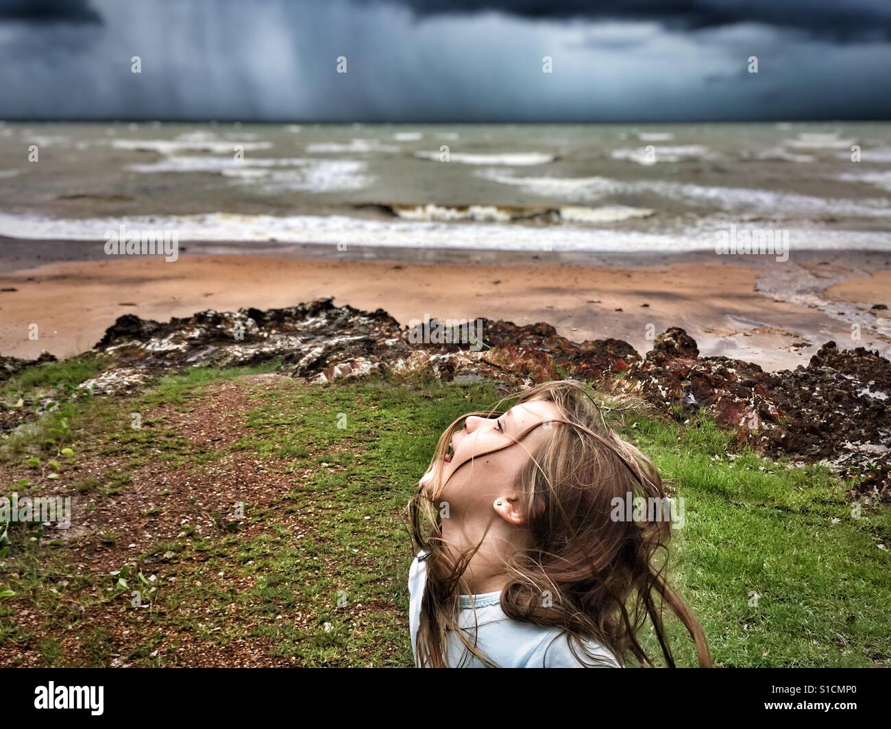 Child playing in front of the incoming storm Stock Photo - Alamy