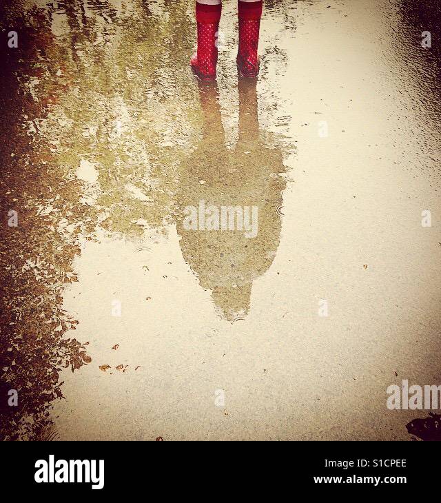 Red wellies in a puddle Stock Photo - Alamy
