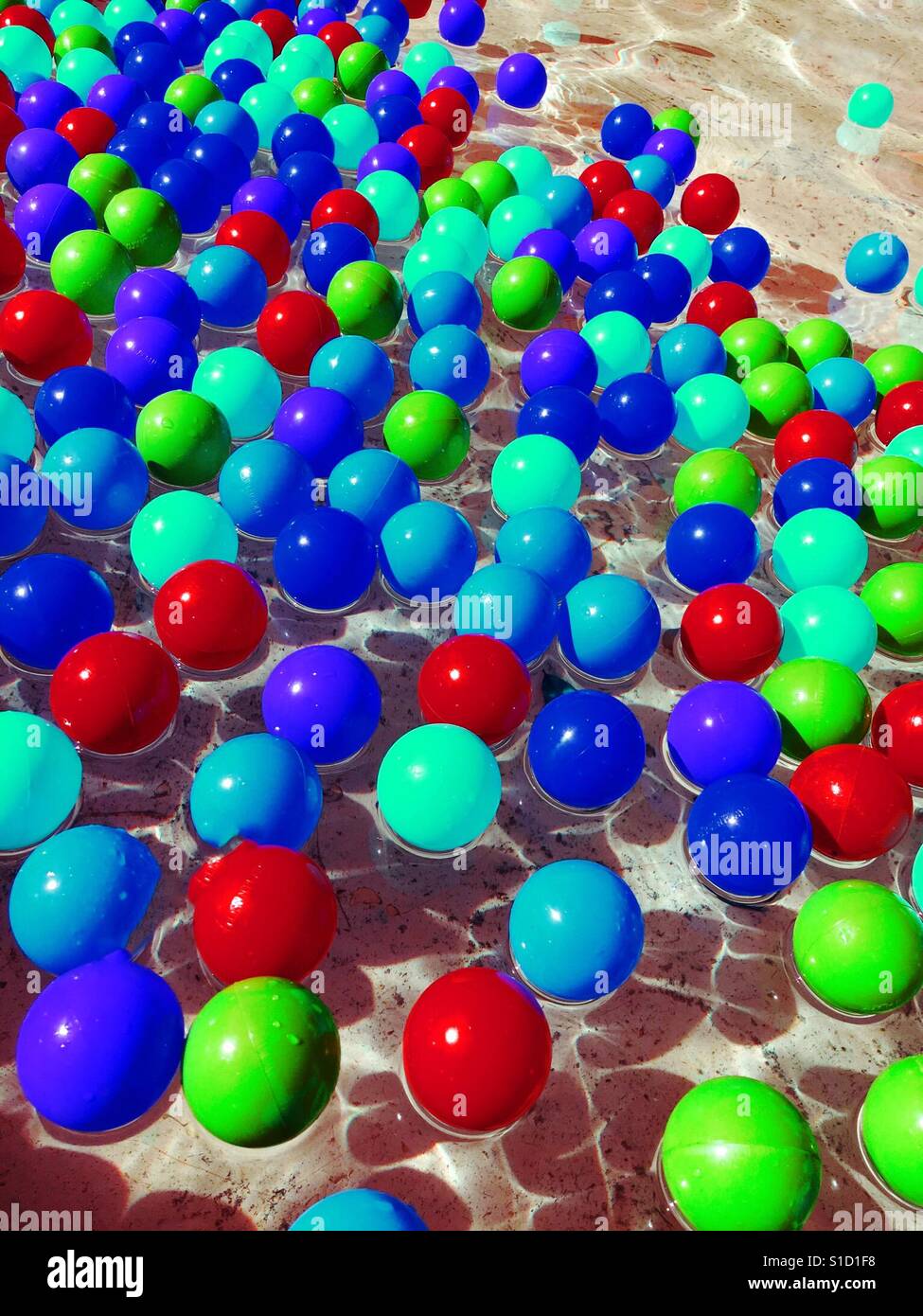 Colorful plastic balls floating on water Stock Photo - Alamy