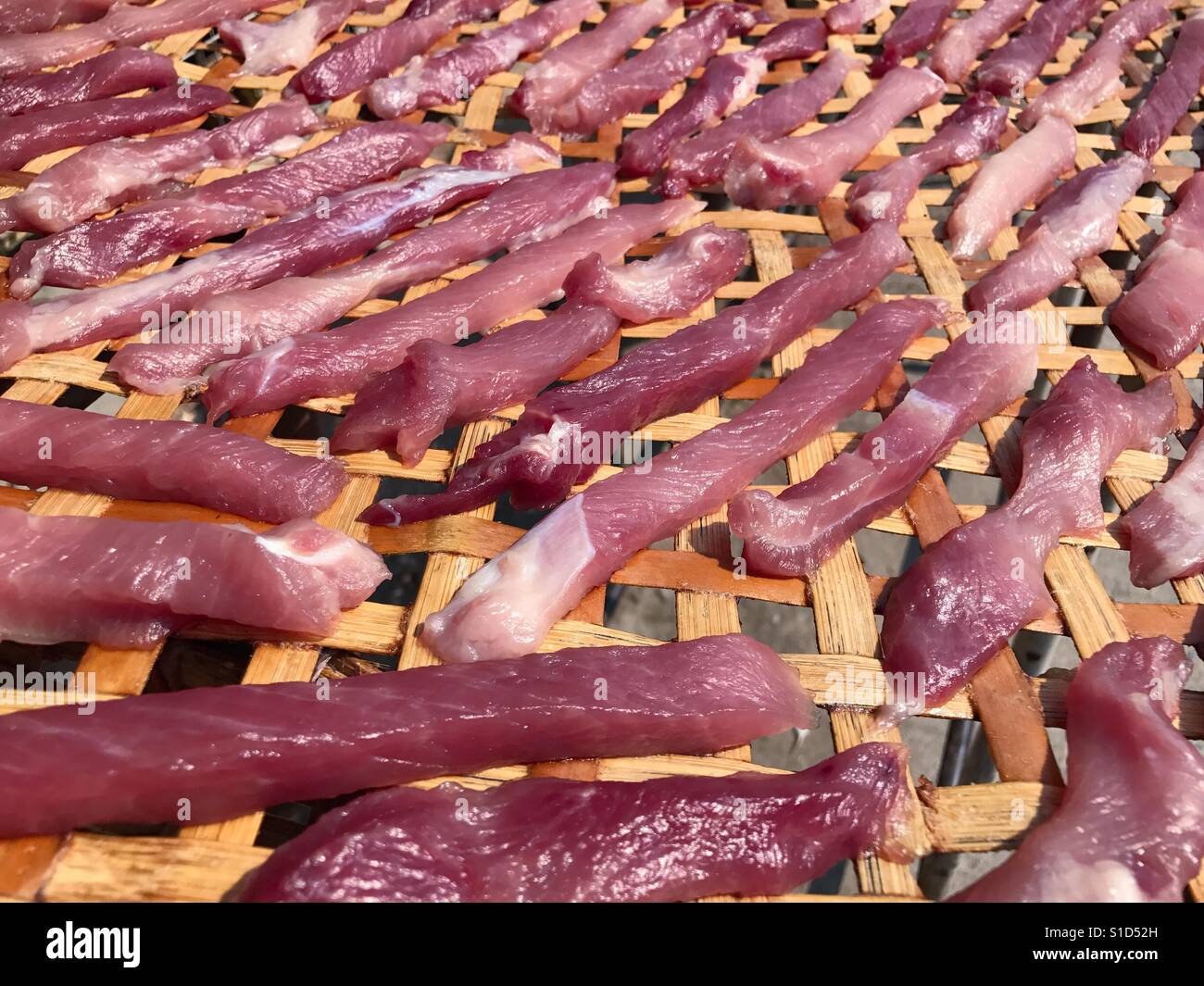 Preserved sun dried pork on bamboo basket Stock Photo - Alamy