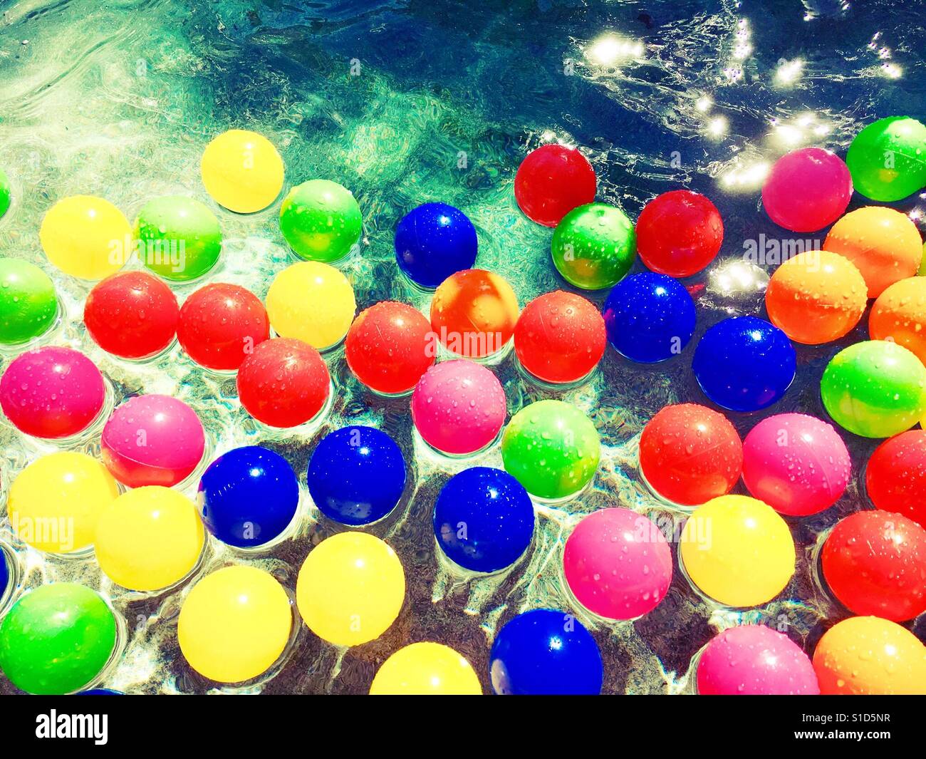Colorful plastic balls floating on water Stock Photo - Alamy