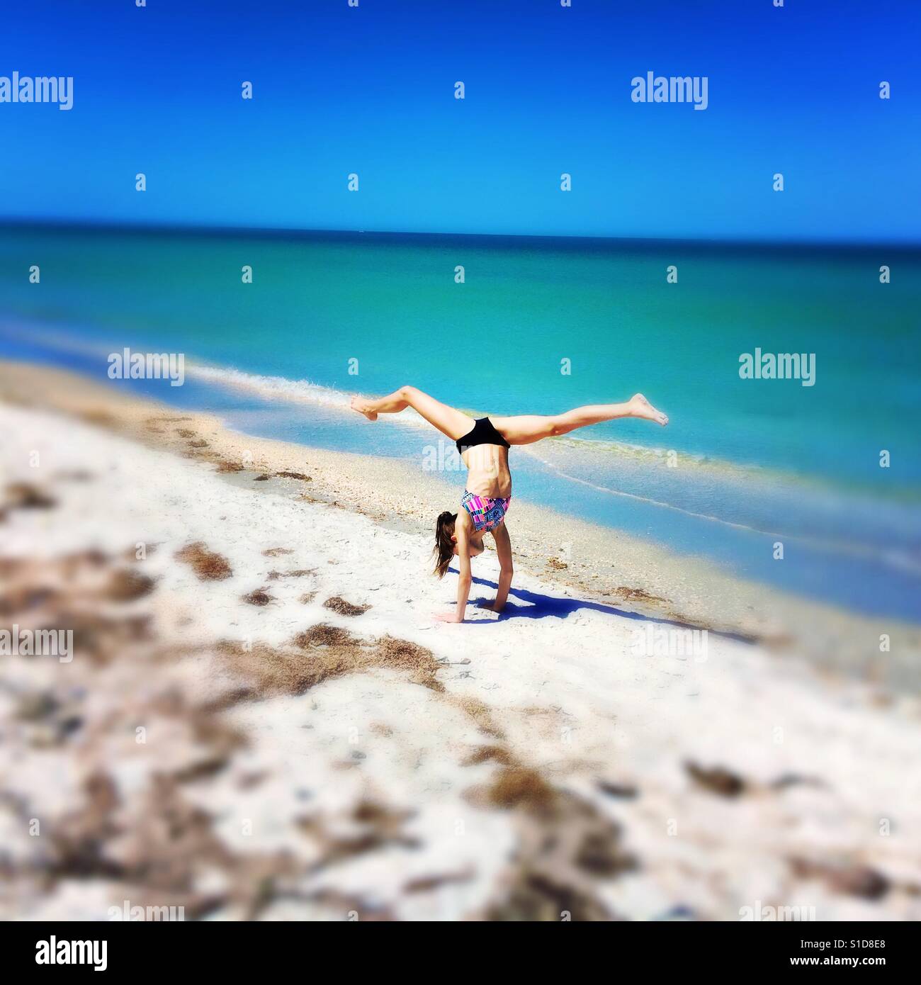 Girl doing acrobatics on a beach Stock Photo - Alamy