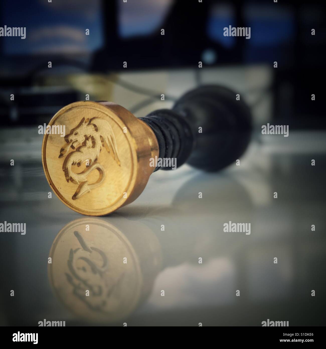 A brass and wood wax seal medallion with a dragon imprint on it Stock ...