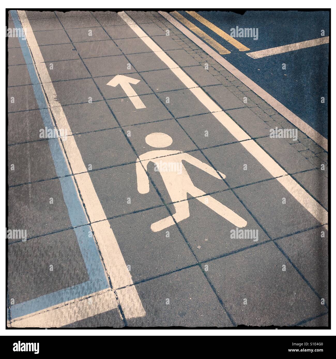 Man walking sign on pavement with arrow Stock Photo - Alamy