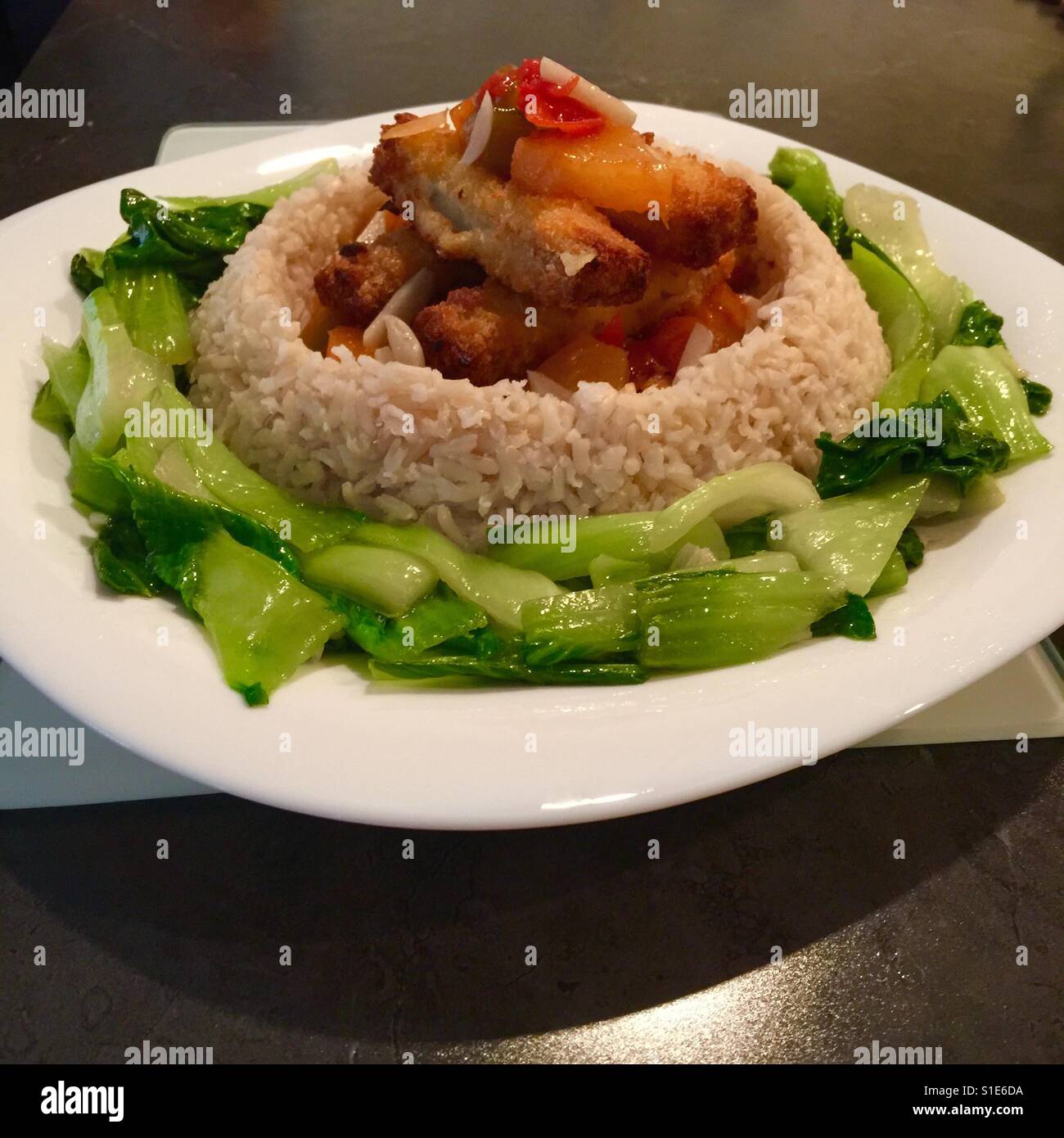 Baked fish with stir fry vegetables served with brown rice and steamed ...