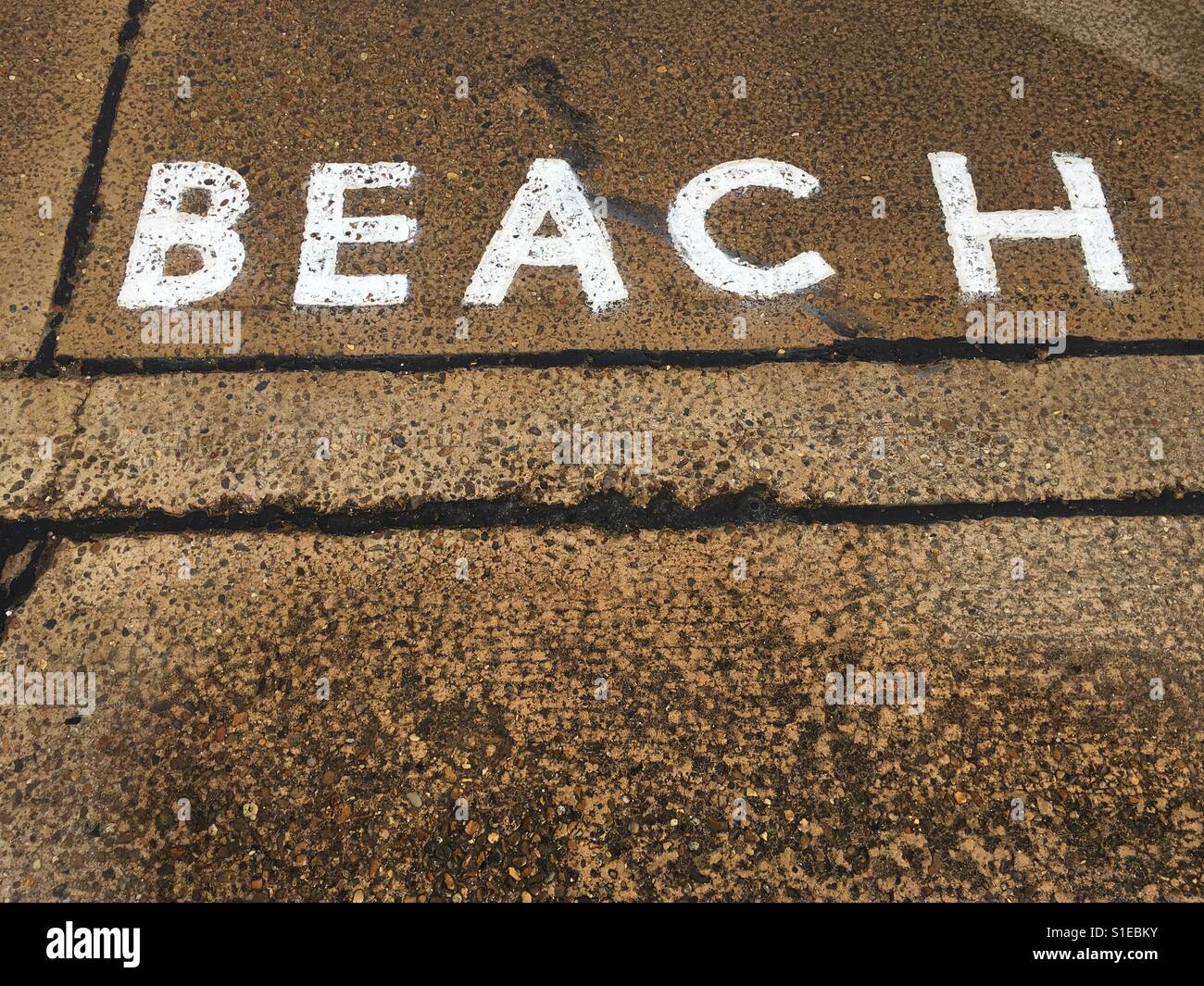 Beach sign painted on to a concrete floor Stock Photo - Alamy