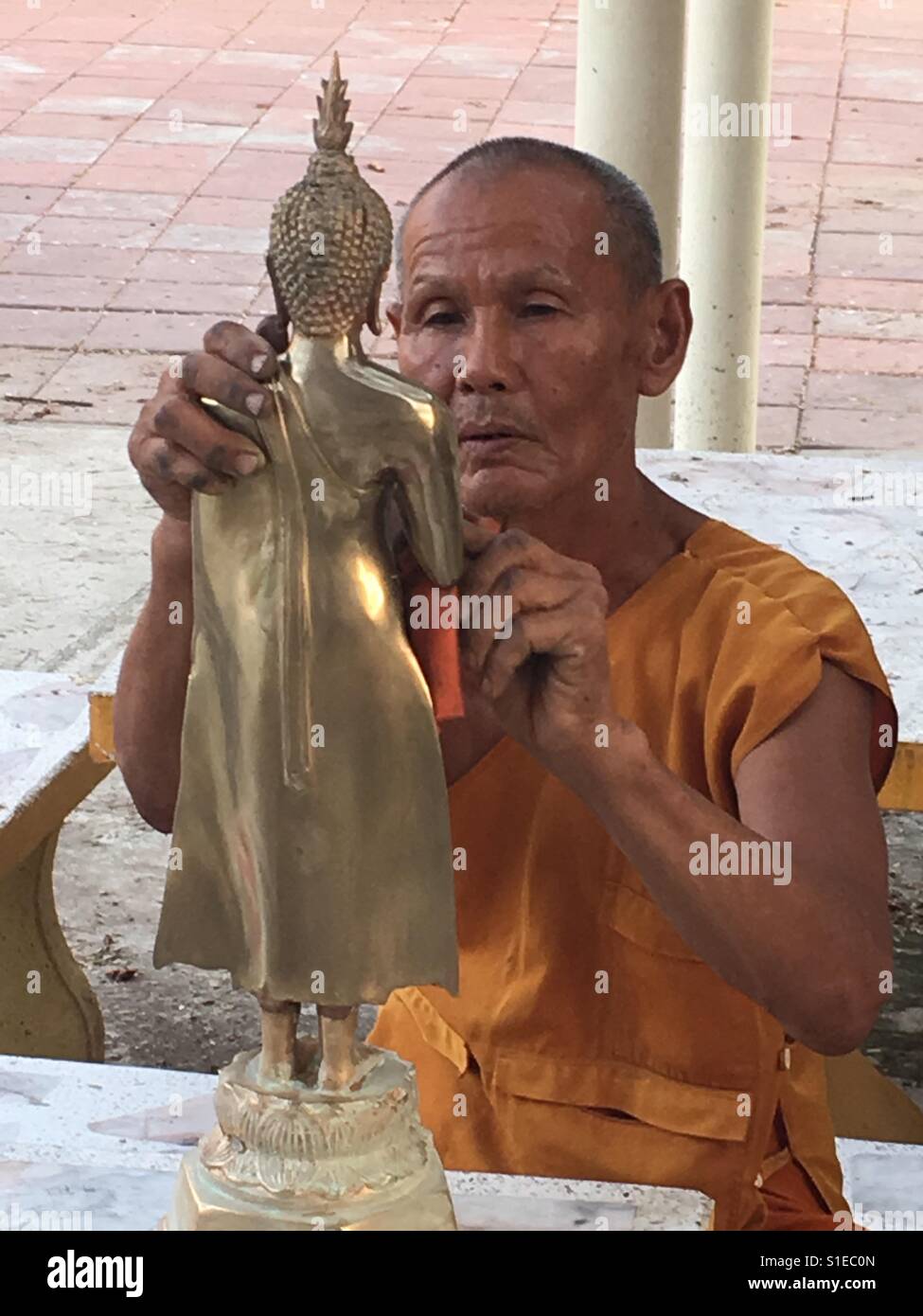 A Buddhist monk shines a Buddha image Stock Photo - Alamy